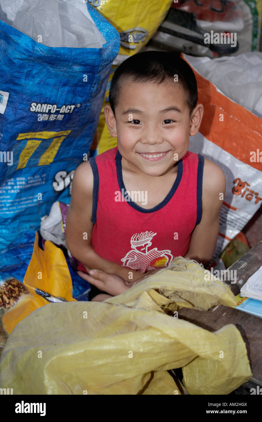 Boy smiling amongst sacks in hutong market Beijing China Stock Photo ...