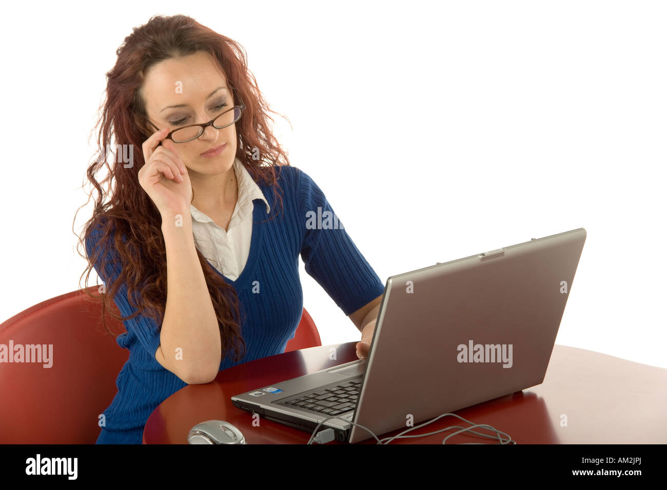 Young woman working on a laptop computer against a white background ...