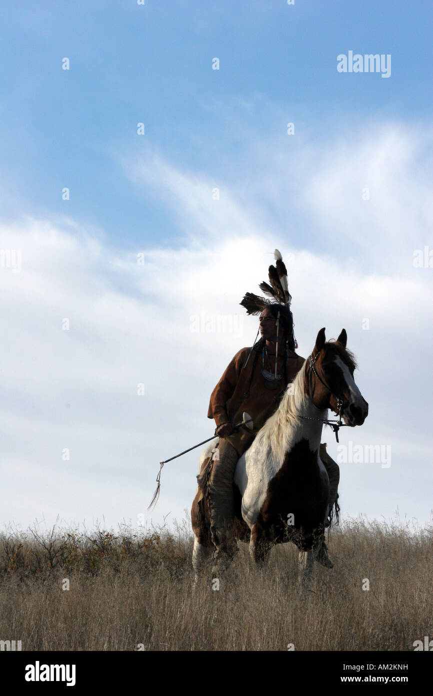 A Native American Indian man sitting bareback on a horse in traditional ...