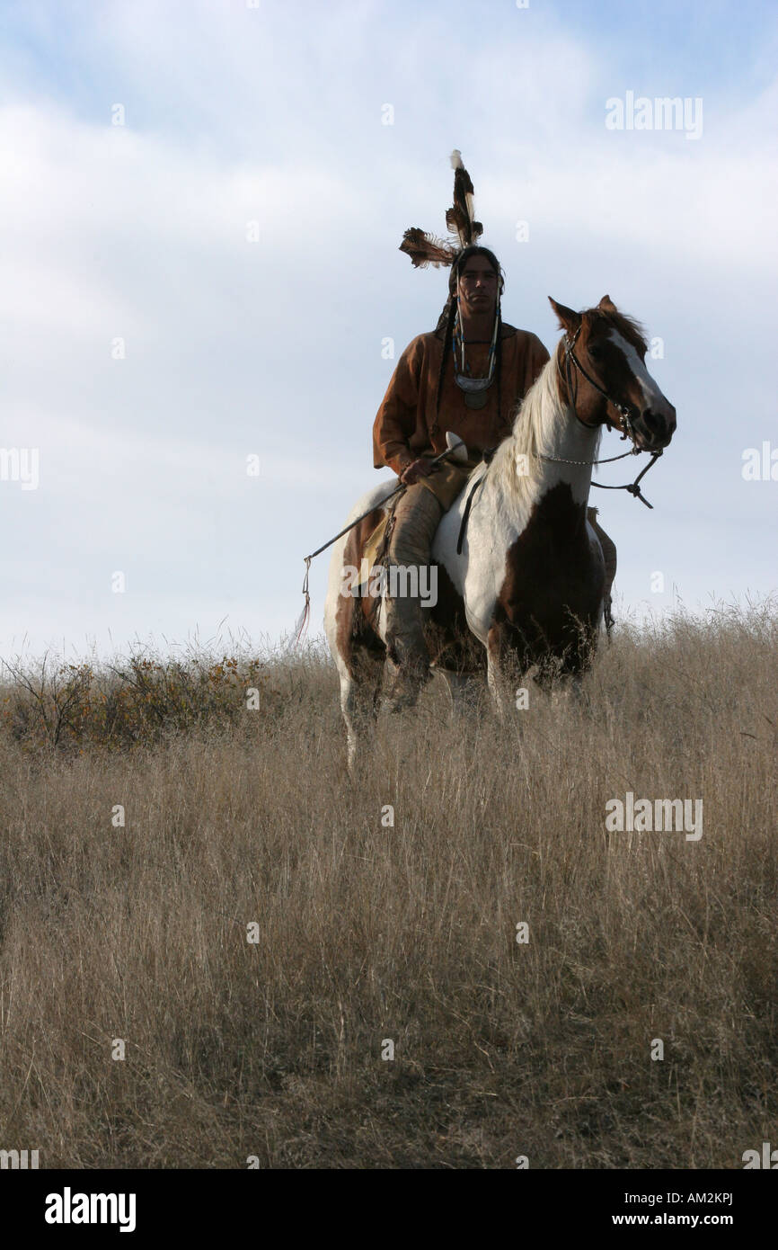 A Native American Indian man sitting bareback on a horse in traditional ...