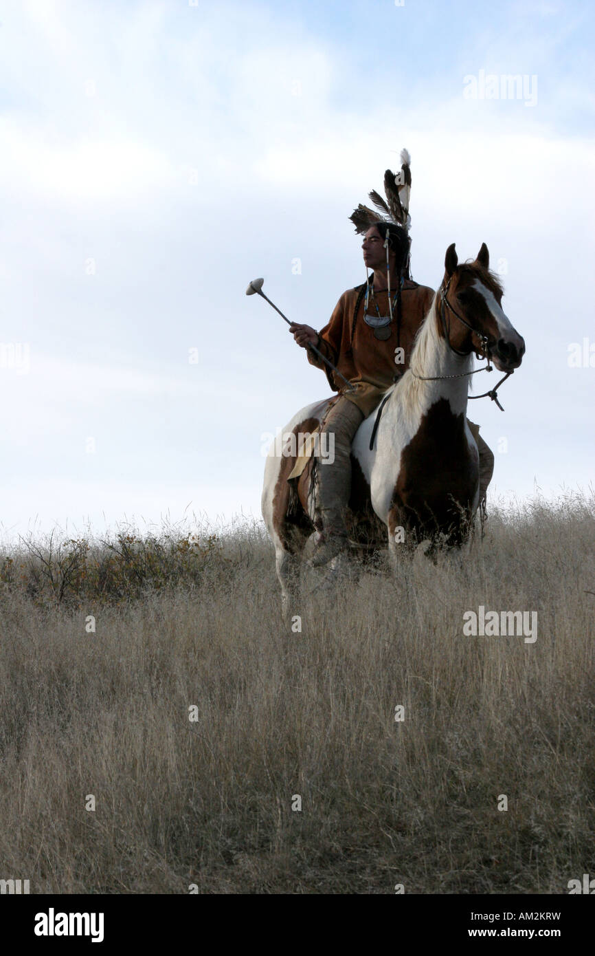 A Native American Indian man sitting bareback on a horse in traditional ...