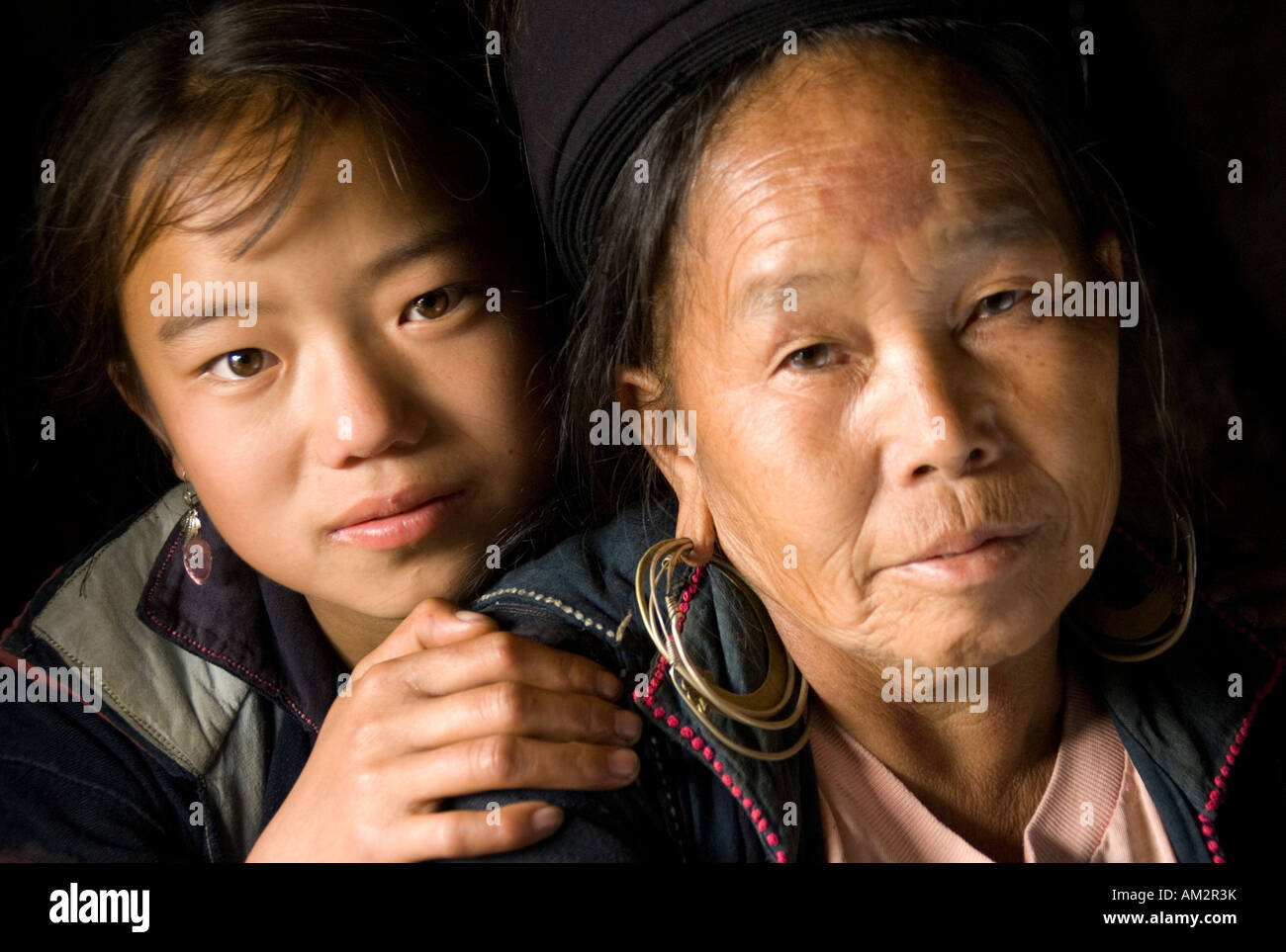 Black Hmong grand daughter with grand mother in village home near Sa Pa ...