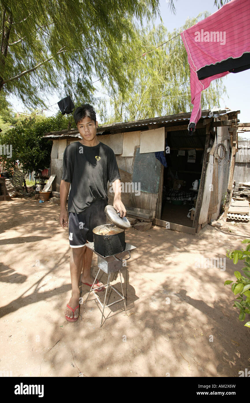 Guarani cooking in front of his hut, in the poor area of Chacarita ...