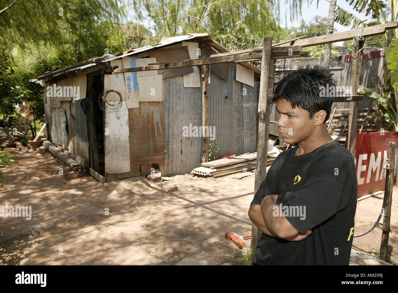 Guarani in front of his hut, in the poor area of Chacarita, Asuncion ...
