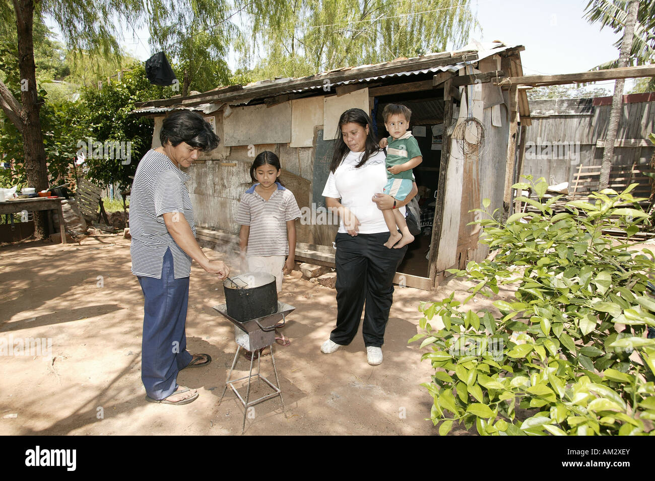 Guarani family cooking in front of their hut, in the poor area of ...