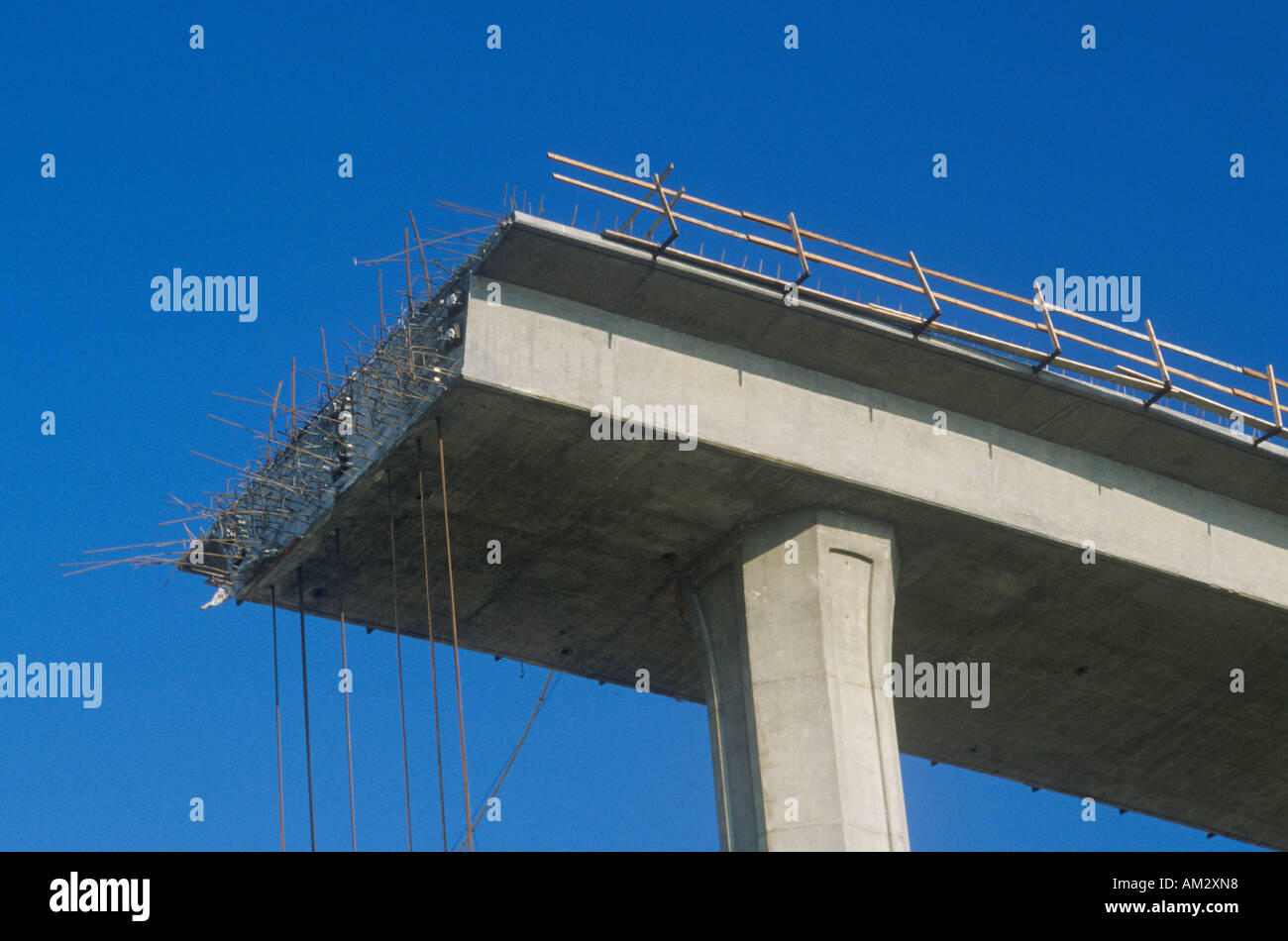 A concrete freeway structure ends abruptly with iron support structures ...