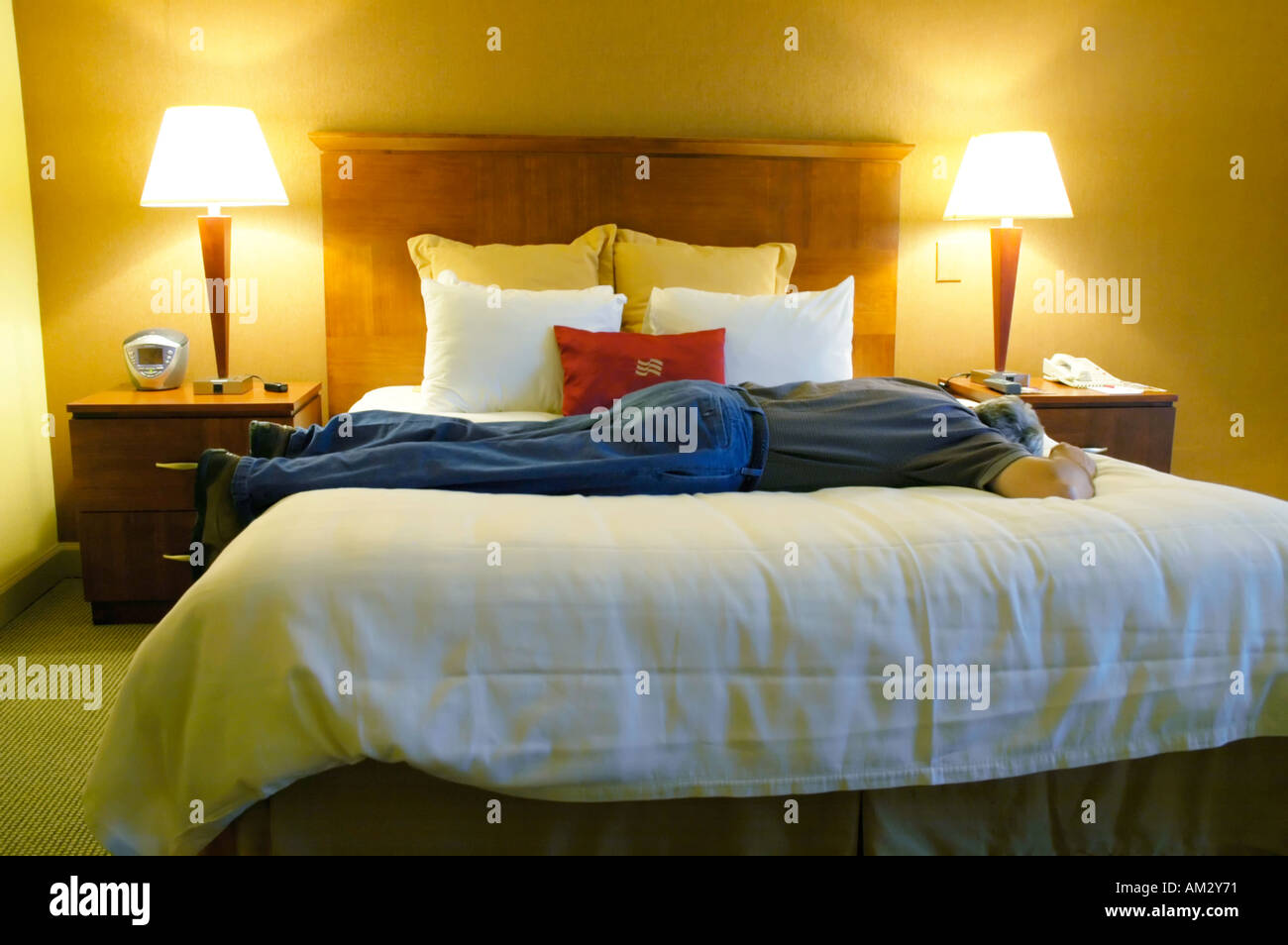 Middle aged man laying across the bed in a hotel room Stock Photo - Alamy