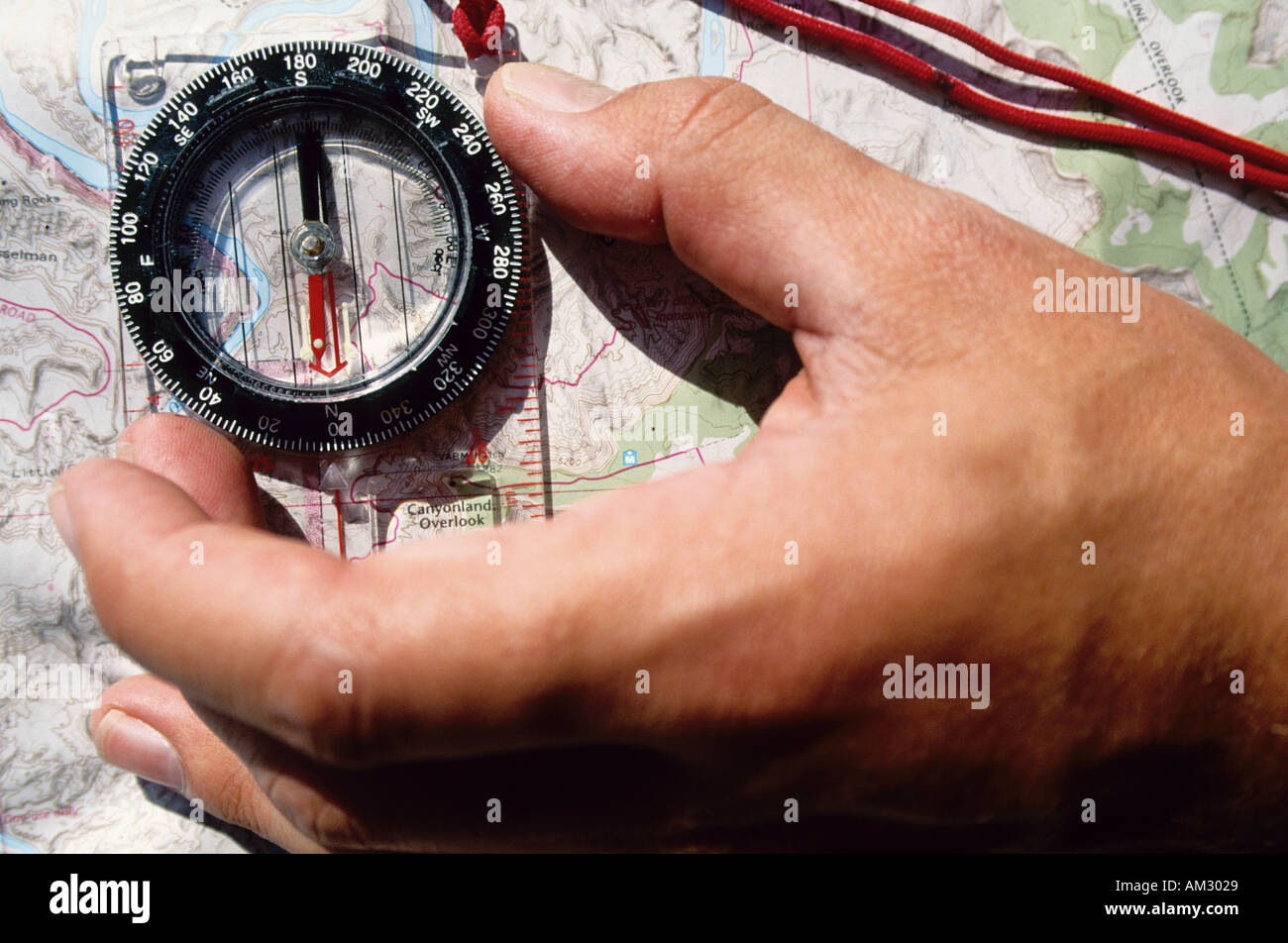 A man reading a compass and a map Stock Photo - Alamy