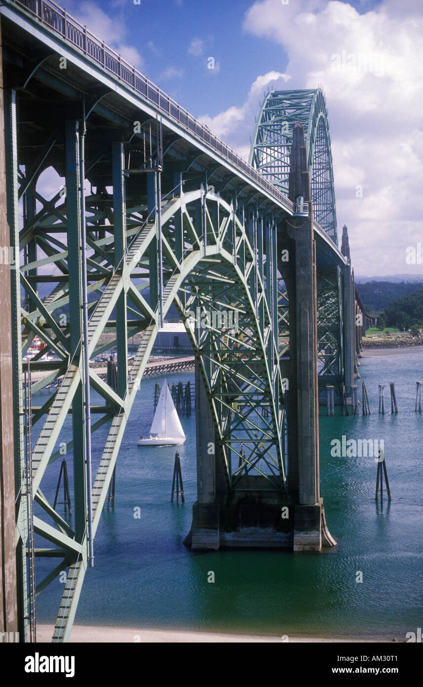 A sailboat under an arched bridge over Yaquina Bay at Newport Oregon ...