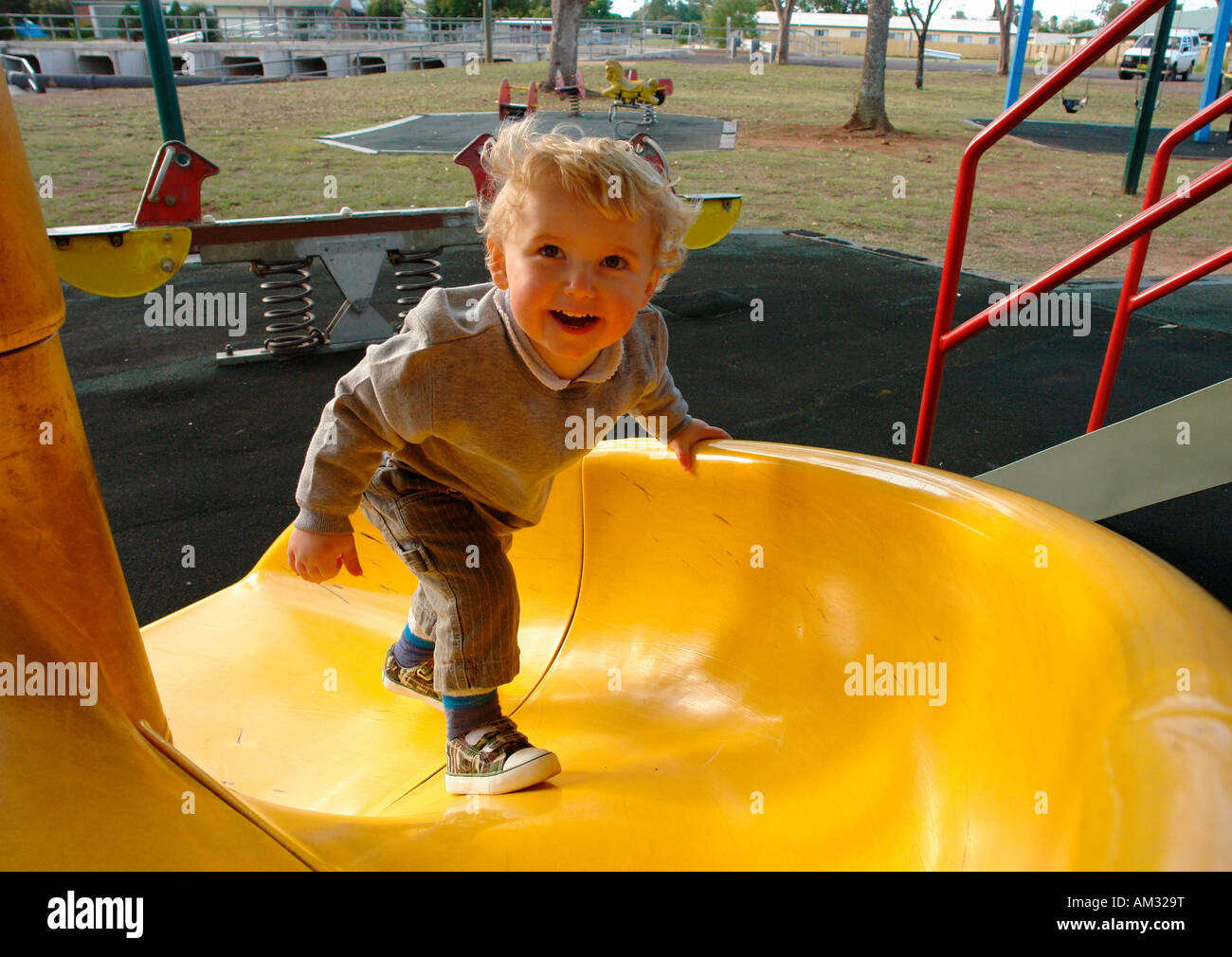 infant boy climbing up a playground slide Stock Photo - Alamy