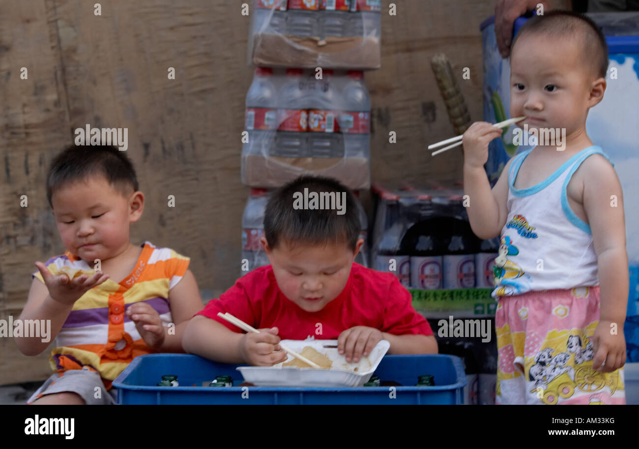Three chinese toddlers eating outside in hutong Beijing China Stock ...