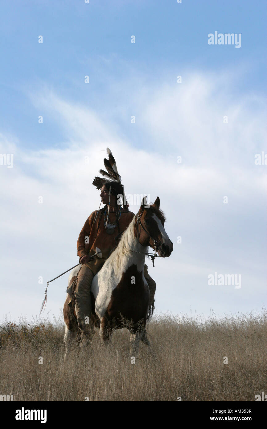A Native American Indian man sitting bareback on a horse in traditional ...