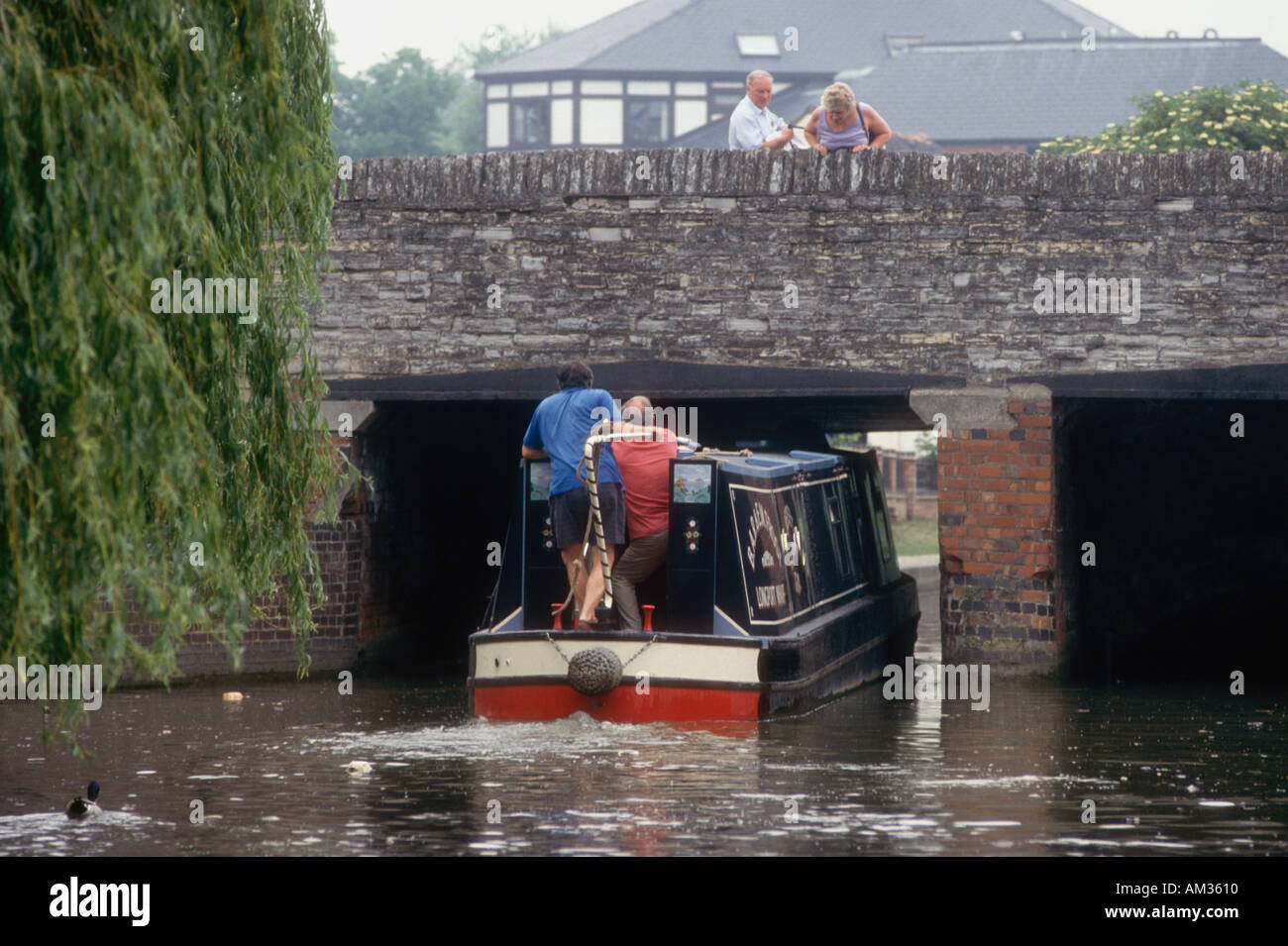 A narrowboat passes beneath bridge 69 on the canal at Stratford upon ...