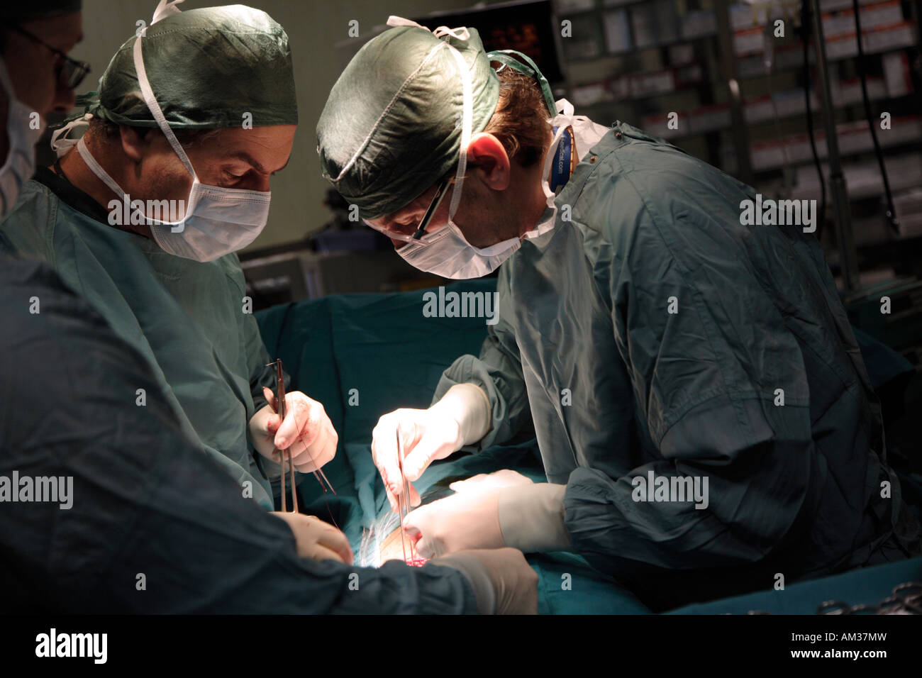 doctors surgeons making incision in patient on operating theatre table ...