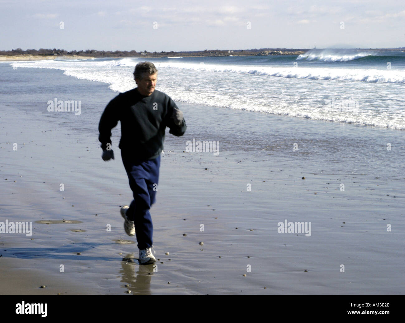 Senior man jogging on ocean beach in winter Stock Photo - Alamy