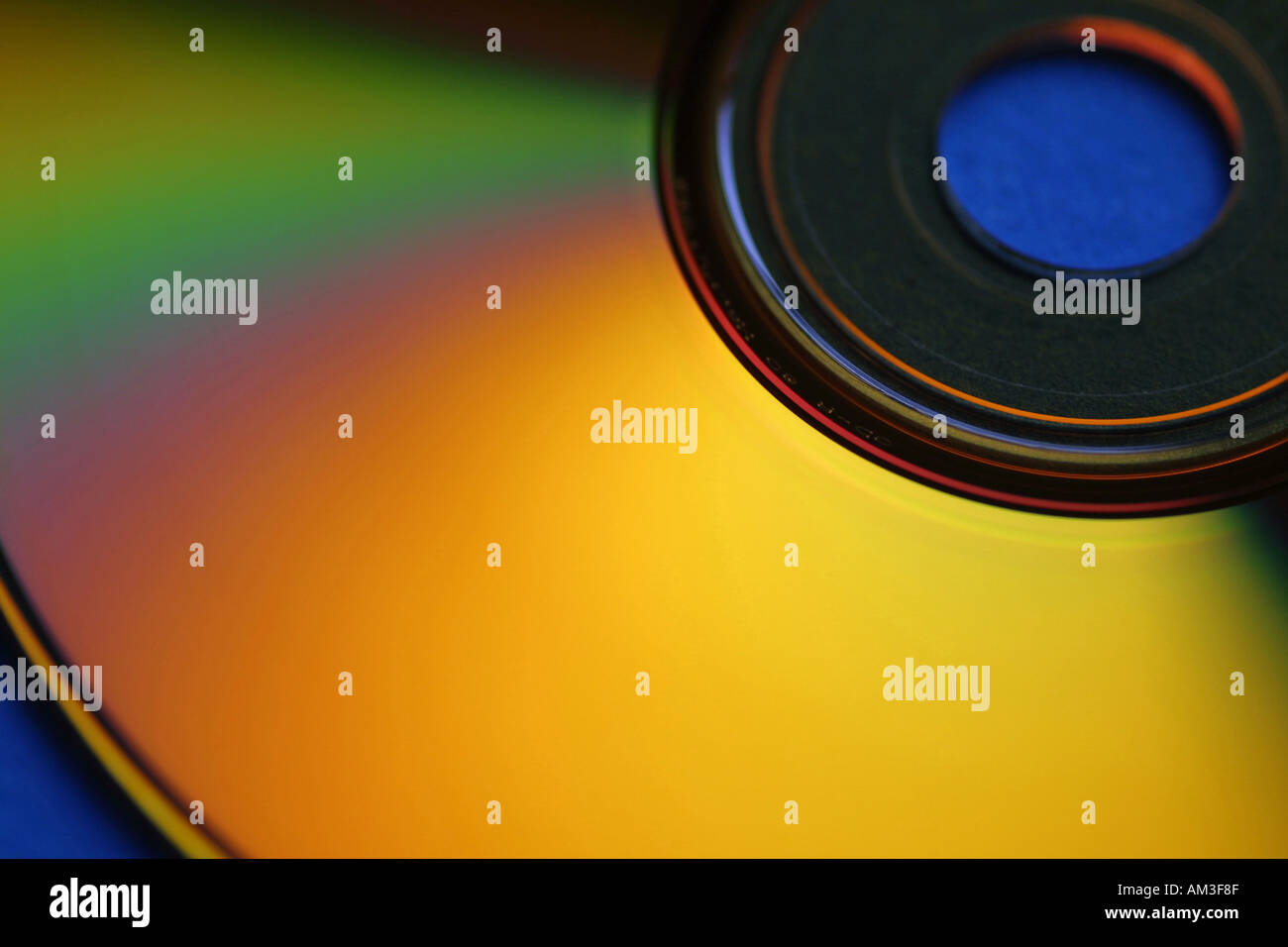 Abstract yellow CD DVD R compact disc close up against a blue ...