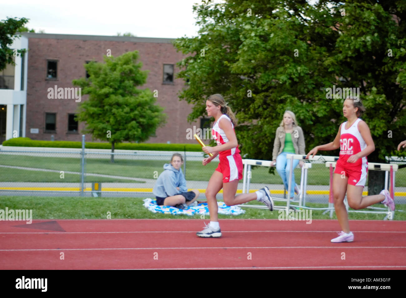 Teenage girl relay race runners at a high school track and field ...