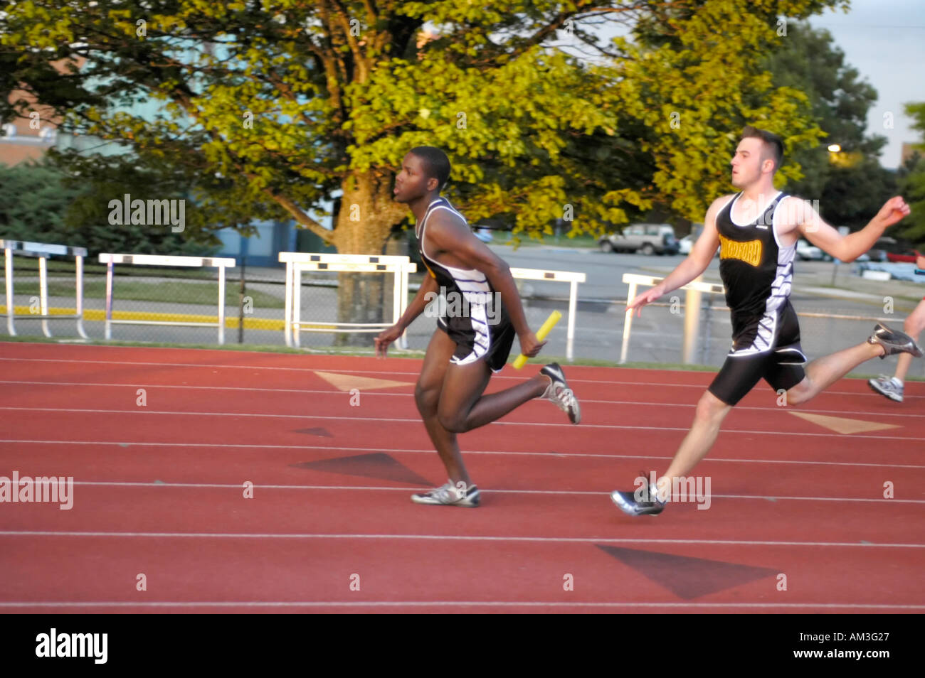 Teenage boy relay race runners at a high school track and field ...