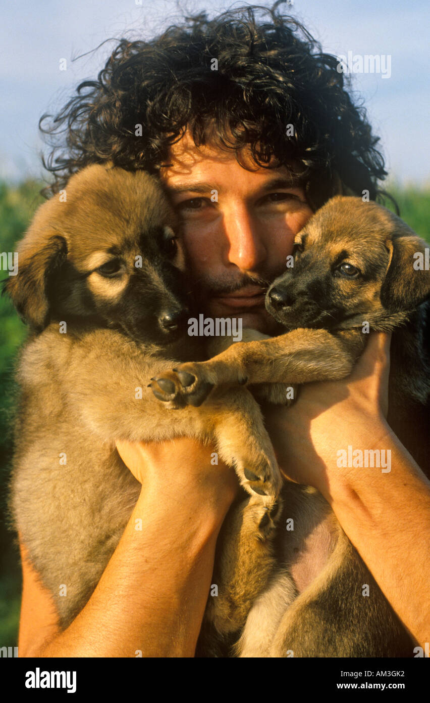 Man with two puppies IN Stock Photo - Alamy