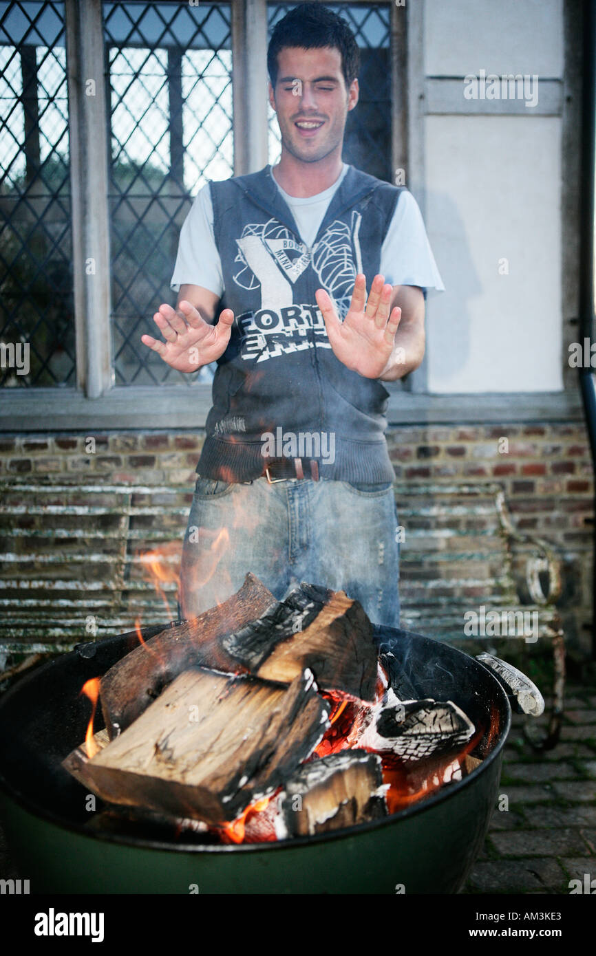 Man warming his hands around a fire Stock Photo - Alamy