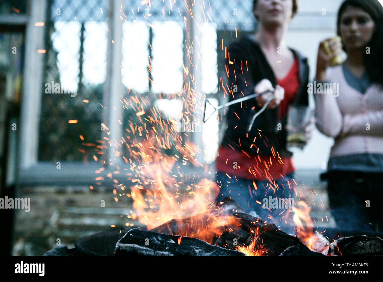 2 women standing at a fire Stock Photo - Alamy