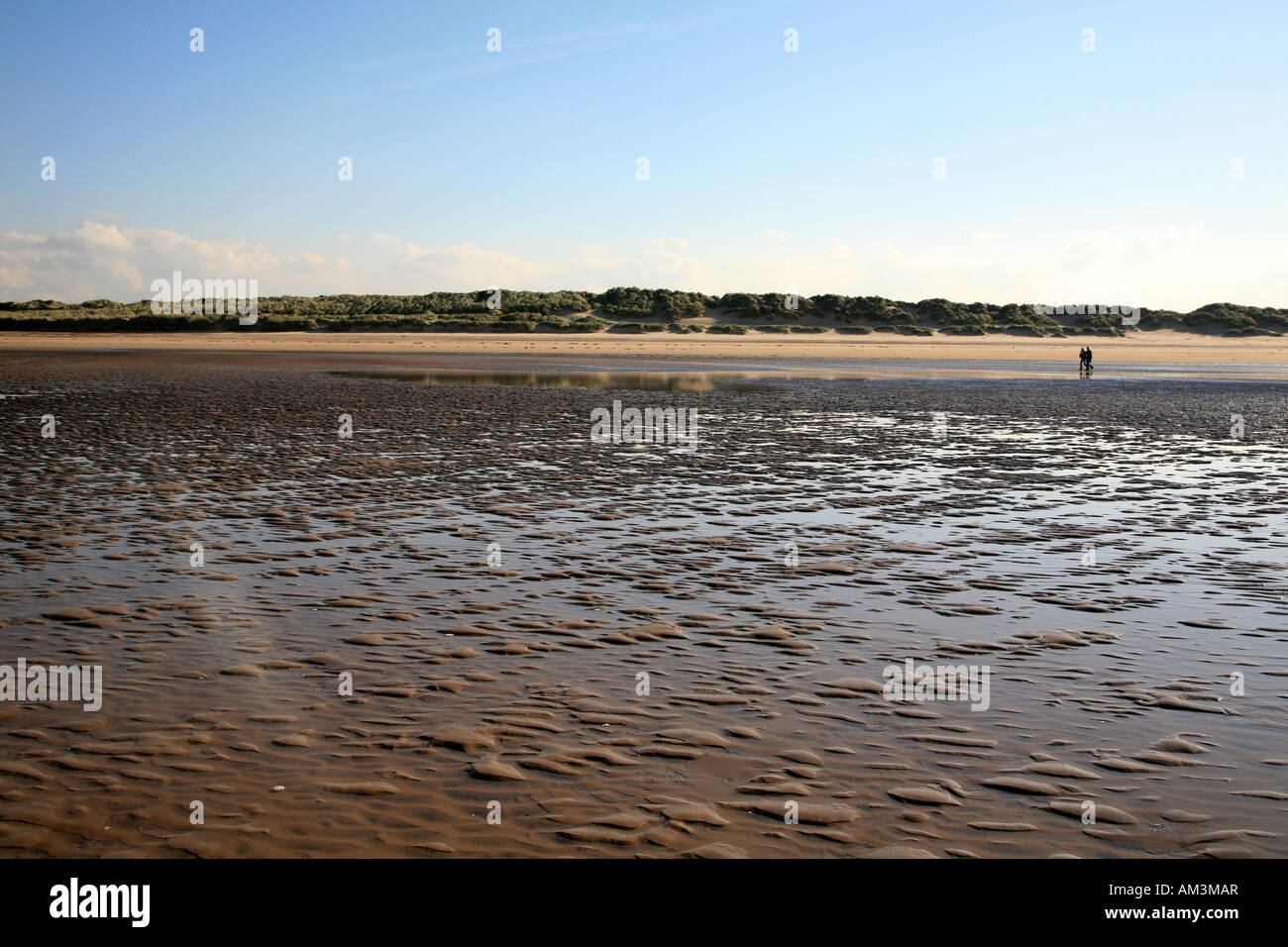 Couple Walking Along Shore. Brancaster, Norfolk UK Stock Photo - Alamy