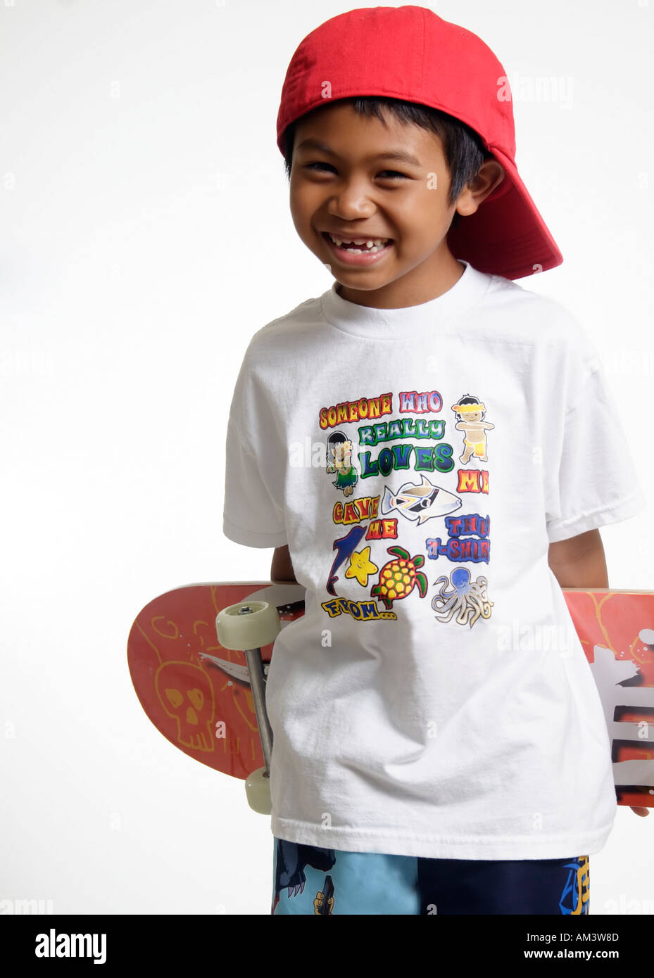 Young boy holding his skateboard behind his back Stock Photo - Alamy
