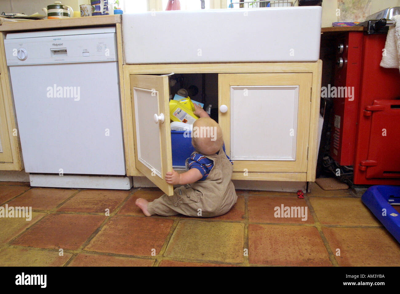 toddler playing in cupboard filled with cleaning solvents Stock Photo ...