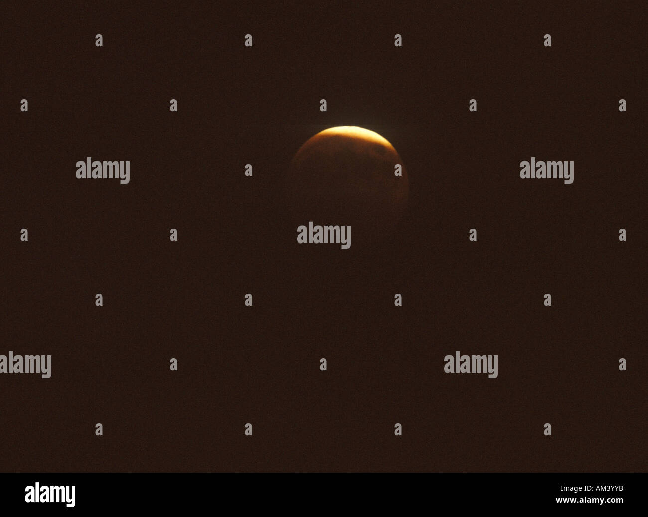 A full moon mostly covered by Earth s shadow during a lunar eclipse ...