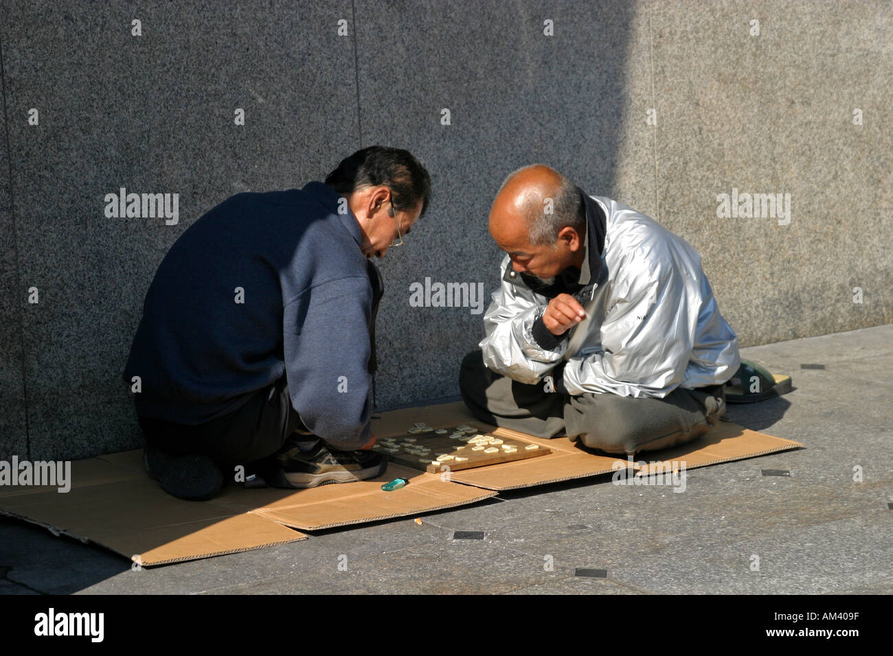 Two homeless tramps street men play Shoji Japanese chess in Nagoya city ...