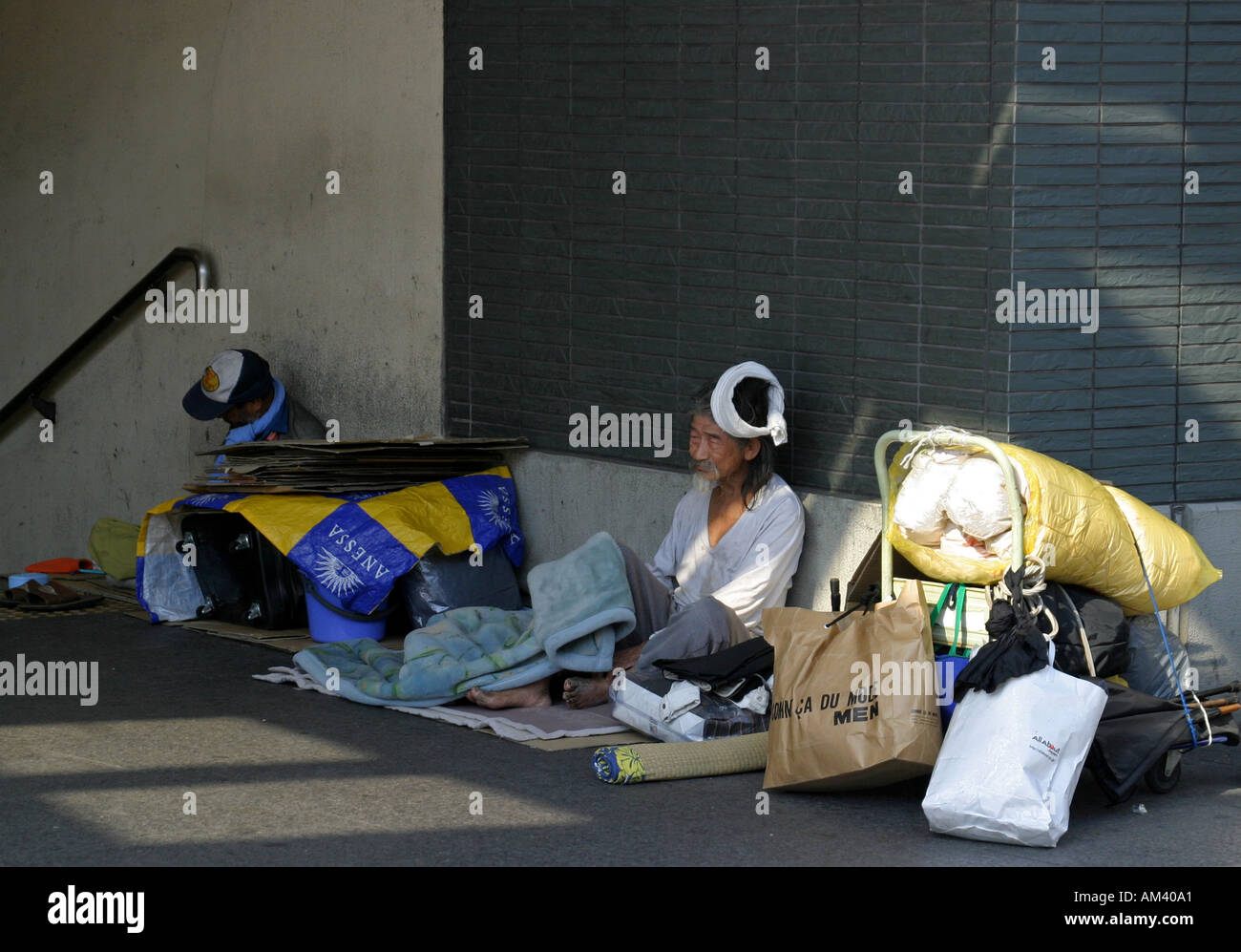 A homeless man tramp sleeps rough outside a train station exit in ...