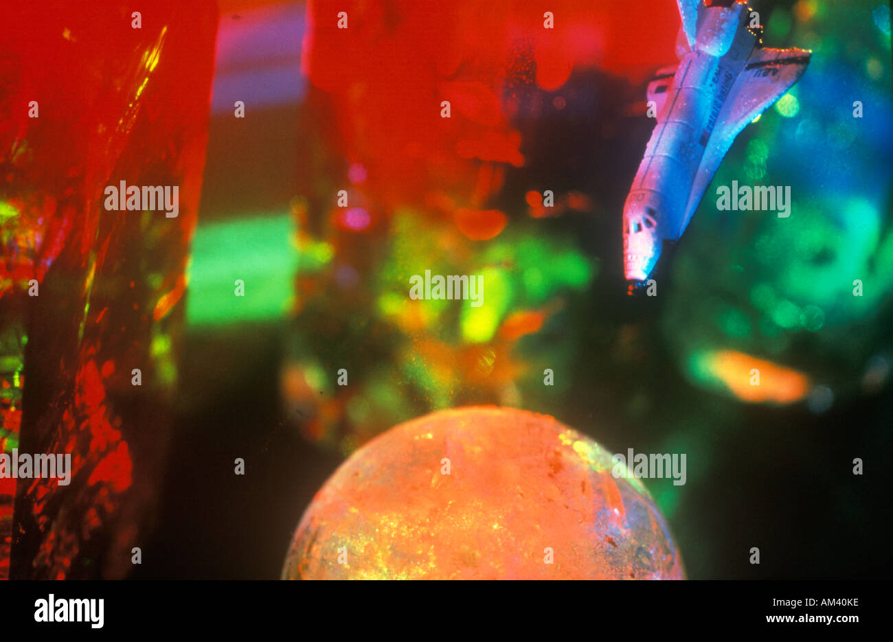 A glowing crystal sphere and spaceship against a multi colored ...