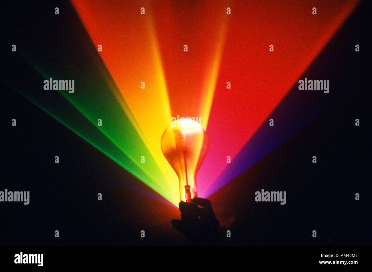 A lightbulb illuminated with an array of rainbow colors from a laser ...
