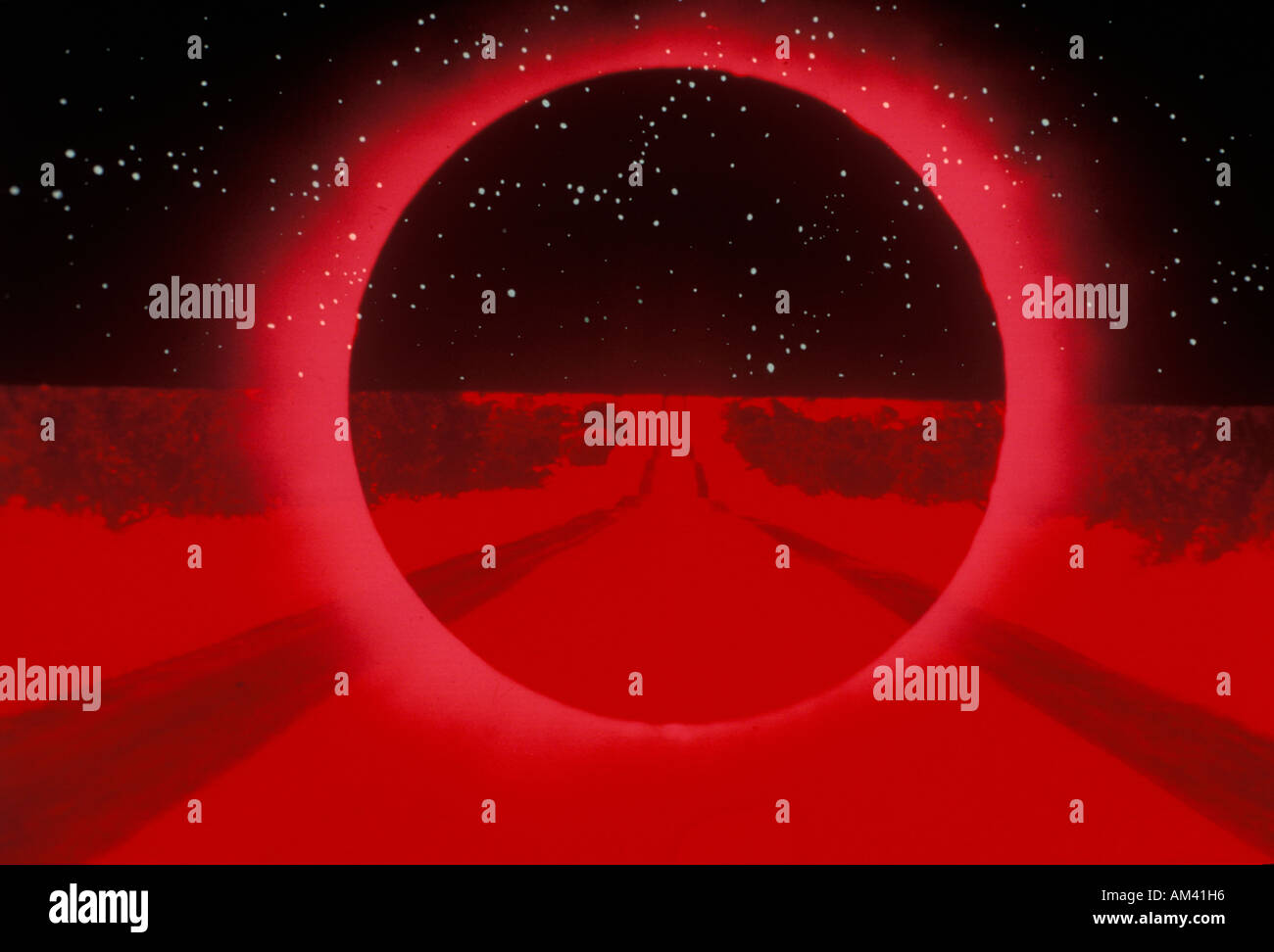 A black sun glowing red superimposed over a red nighttime landscape ...