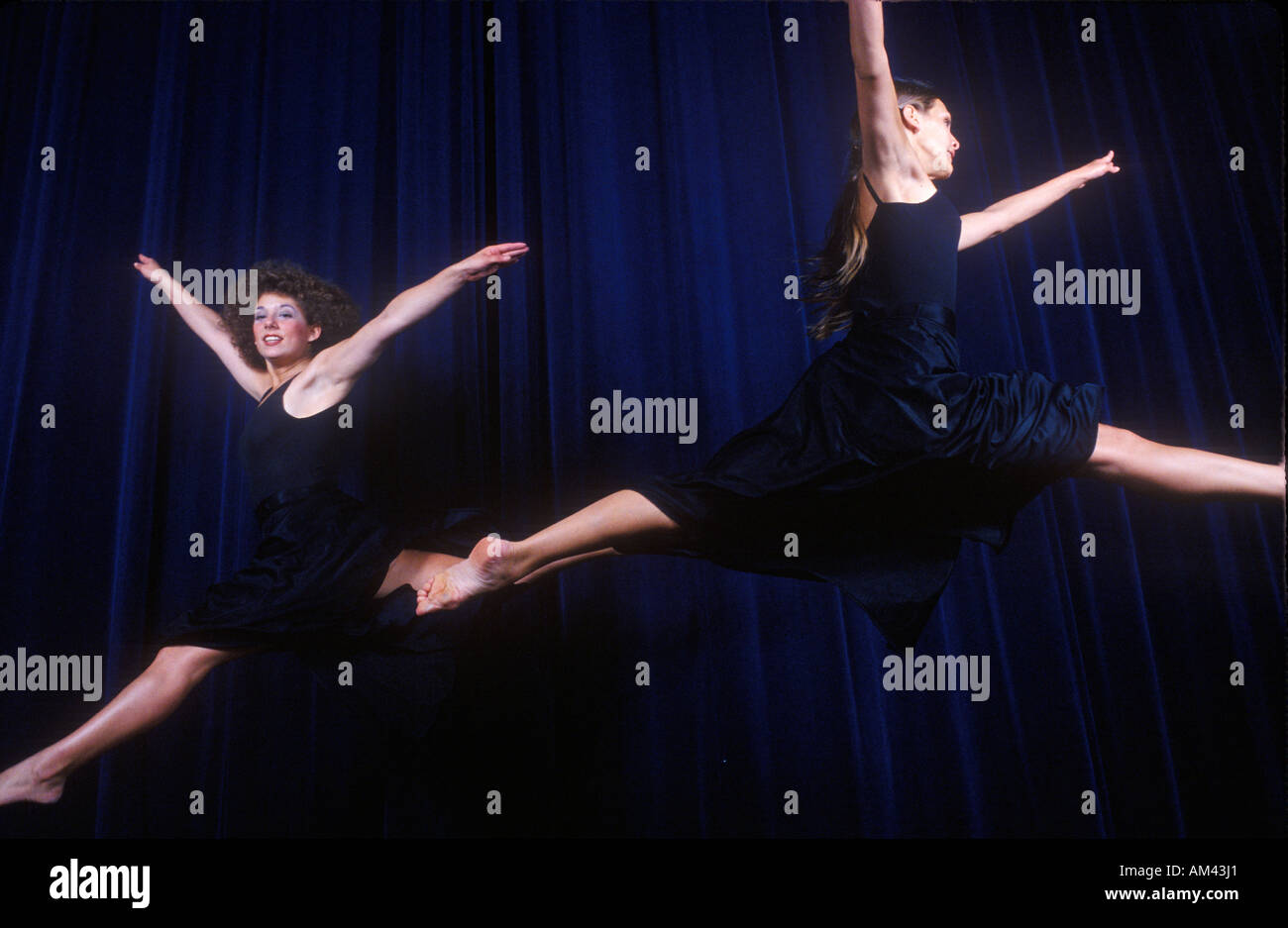 Two dancers leaping onstage Stock Photo - Alamy