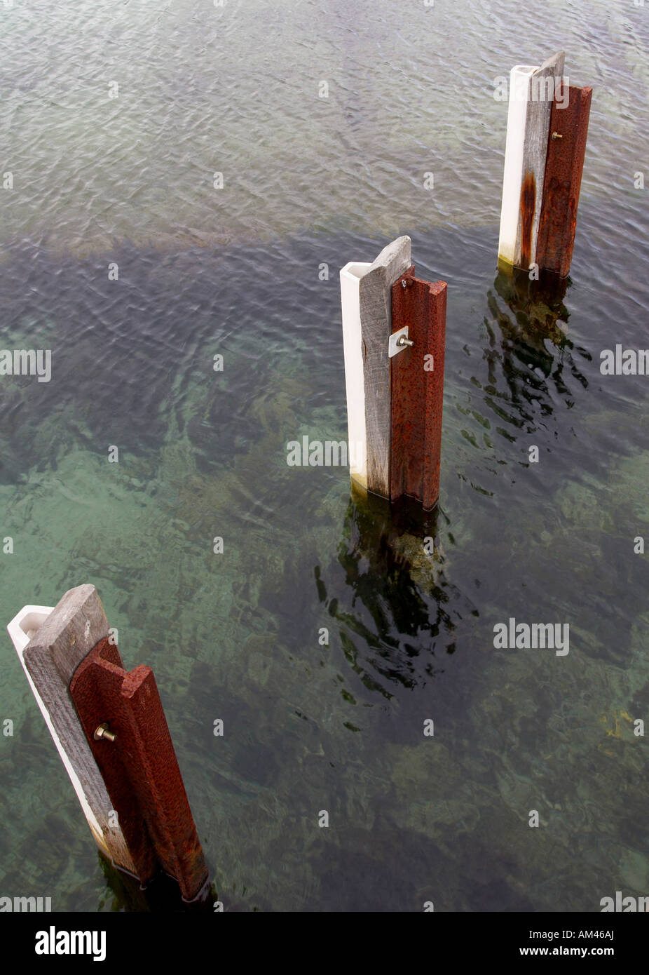 Three poles supports in the water Stock Photo - Alamy