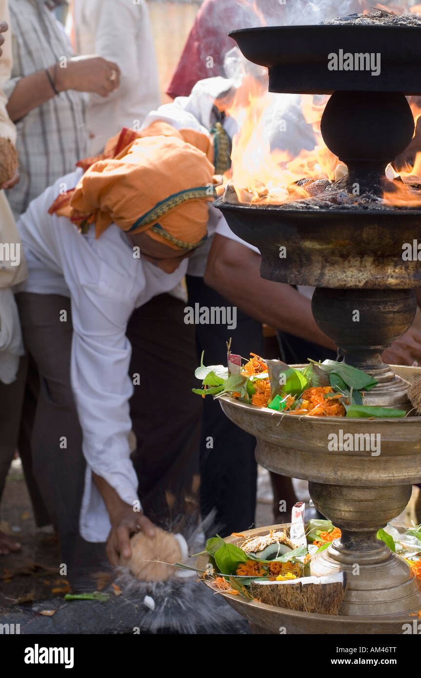 Man making a religious offering of coconut, Tirupati, Tirumala ...