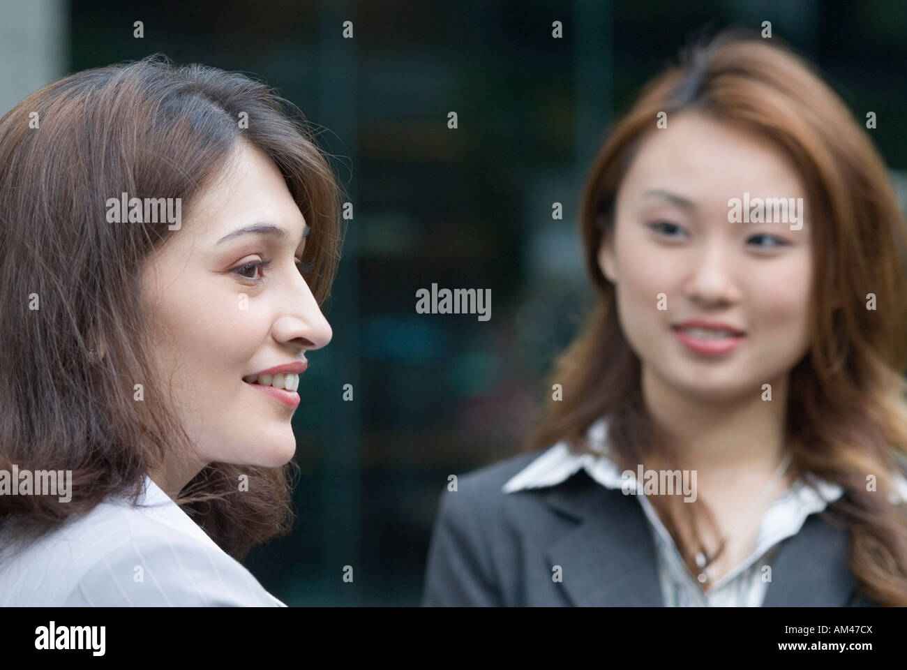 Close-up of two businesswomen smiling Stock Photo - Alamy