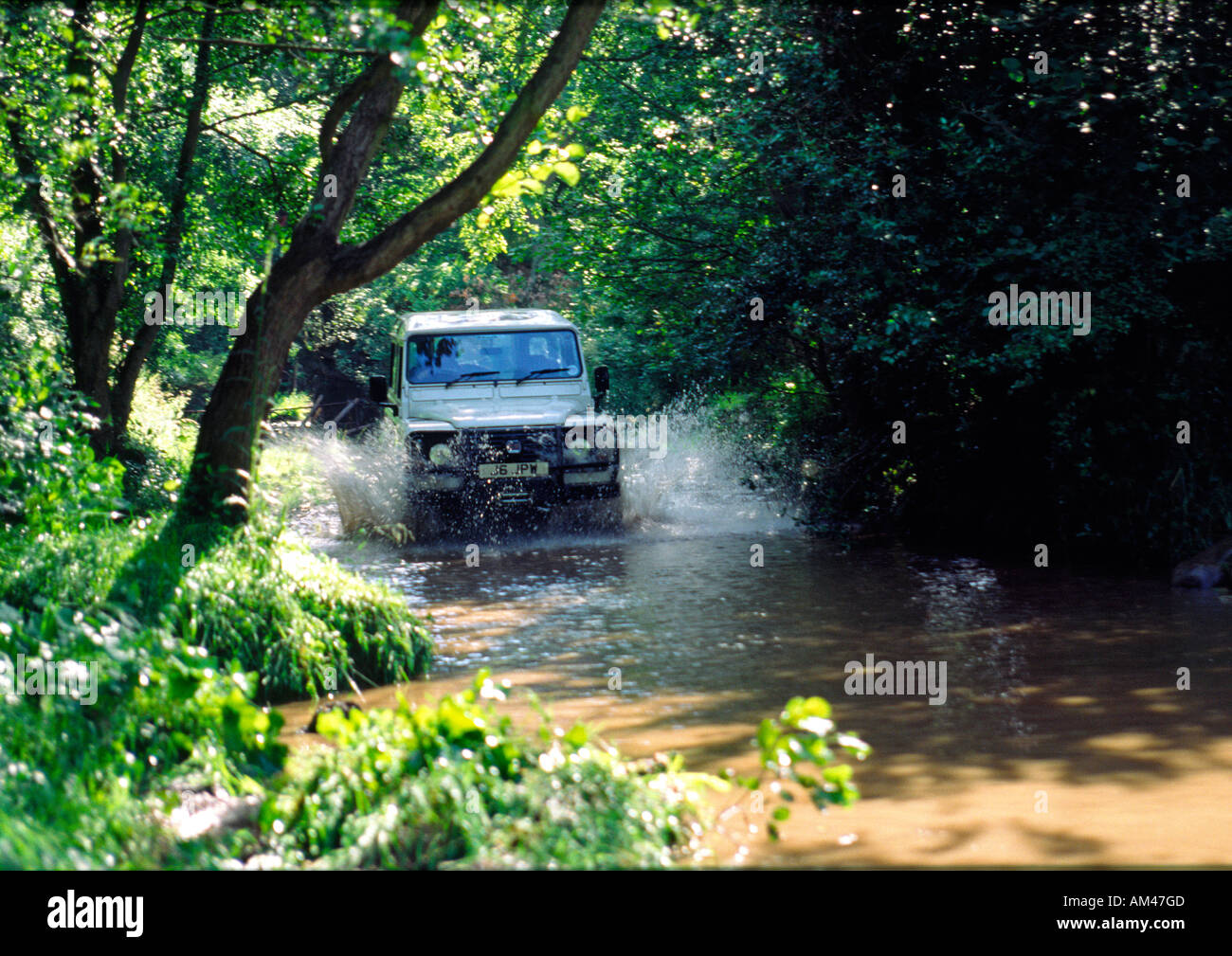 Land Rover splashing through a water ford Stock Photo - Alamy