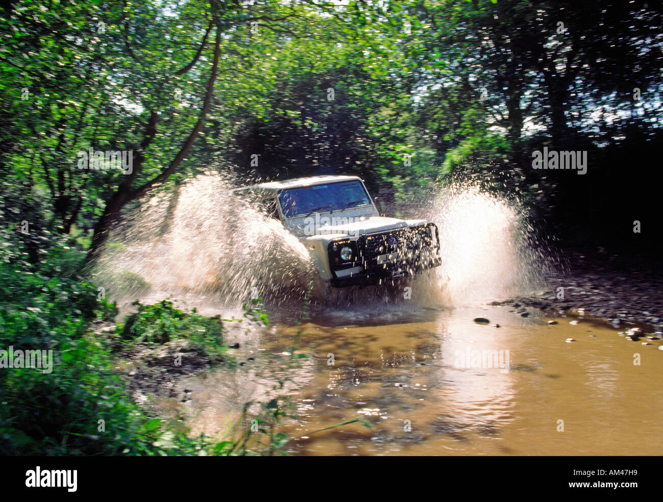 Land Rover splashing through a water ford Stock Photo - Alamy