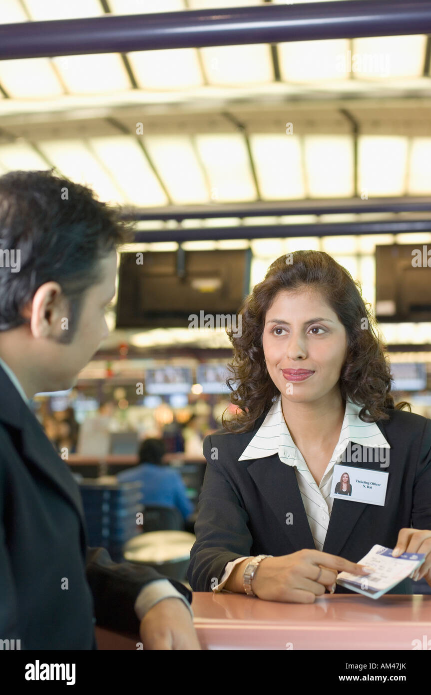 Businessman with an airline check-in attendant at an airport check-in ...