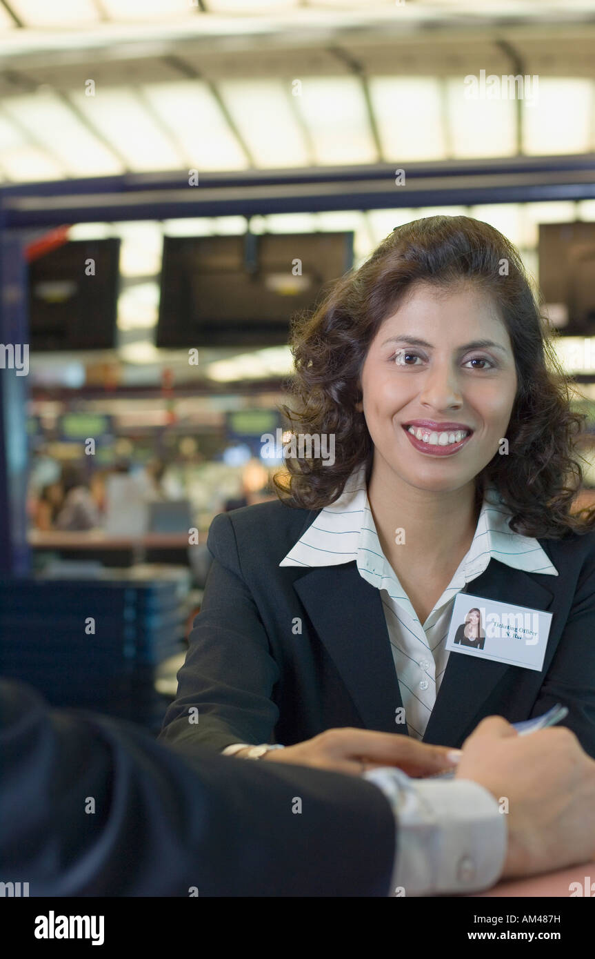 Portrait of an airline check-in attendant smiling Stock Photo - Alamy