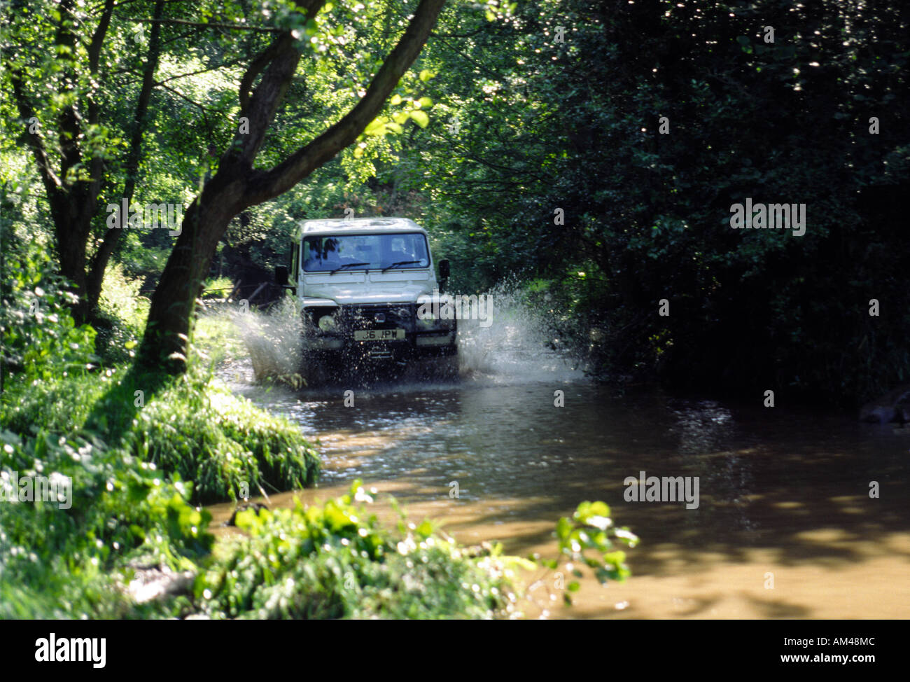Land Rover splashing through a water ford Stock Photo - Alamy