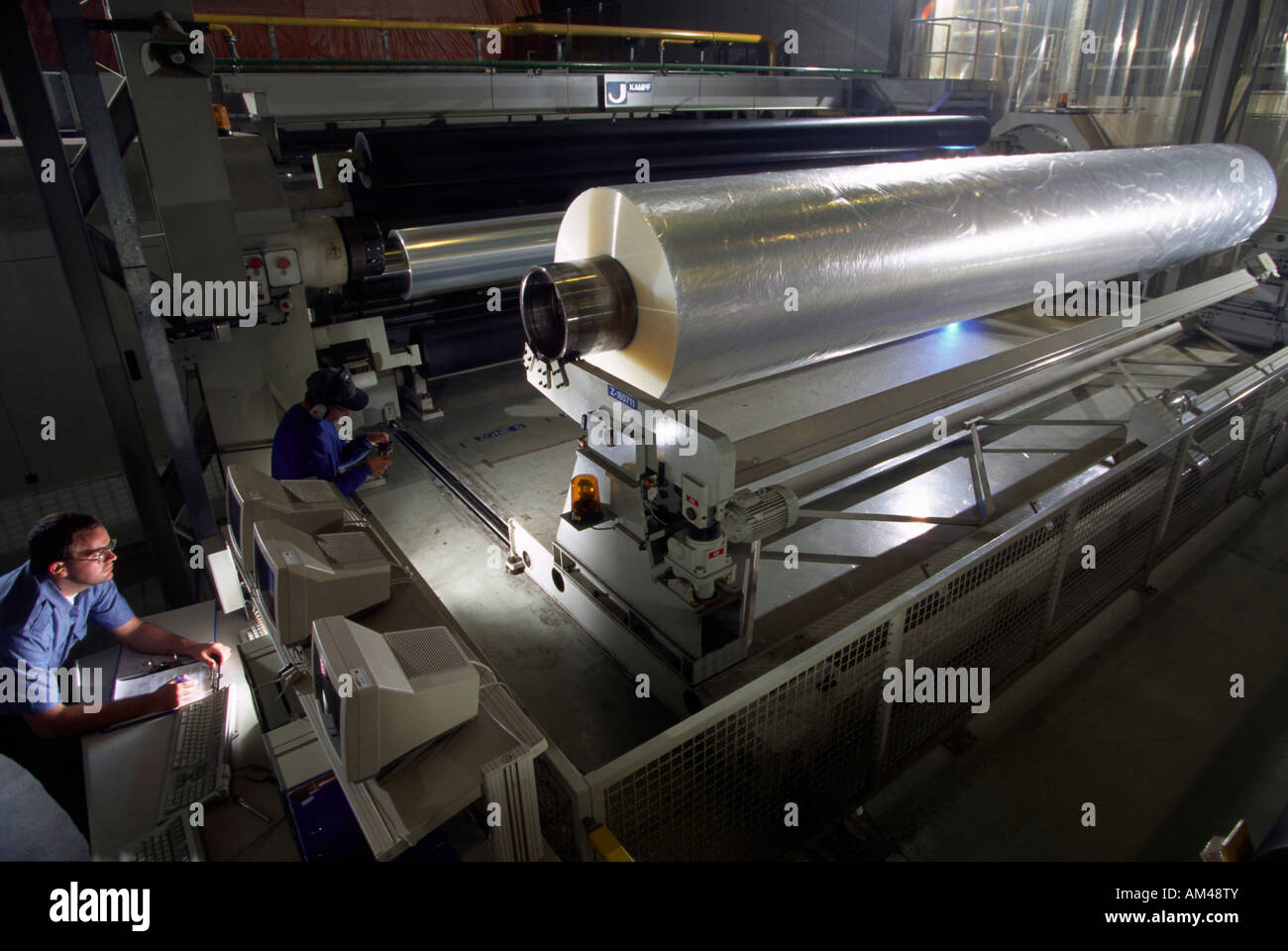 A worker monitors rolls of plastic rap being made at a plant in Holland ...