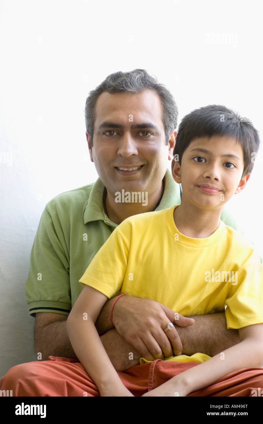 Portrait of a boy sitting with his father Stock Photo - Alamy