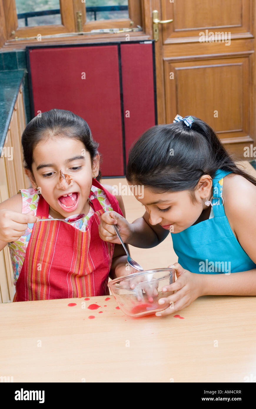 Close-up of a girl eating jam with her sister Stock Photo - Alamy