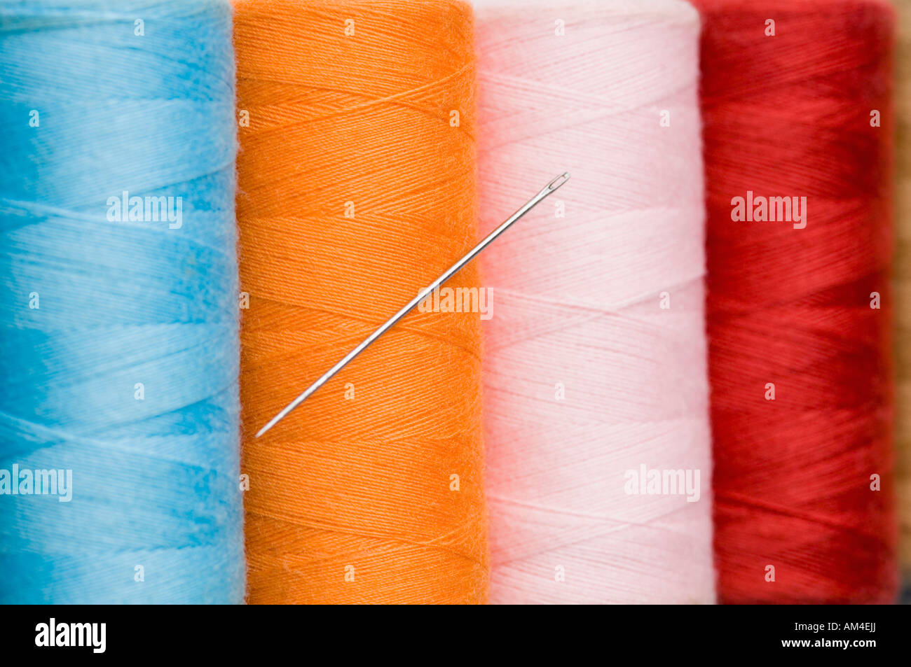 Close-up of a needle with four spools of thread Stock Photo - Alamy