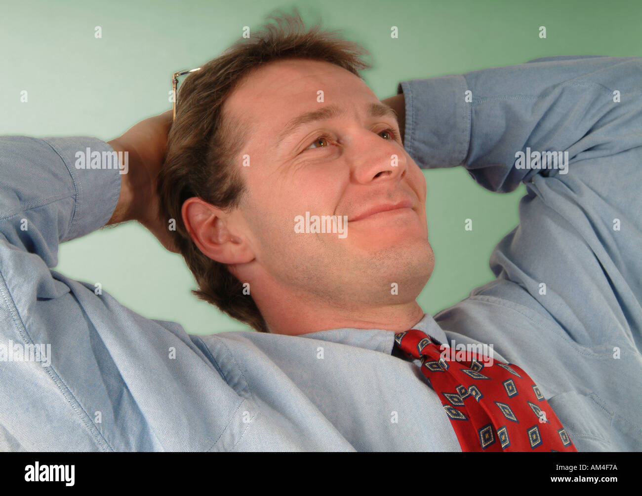 happy man leaning back with head in hands Stock Photo - Alamy