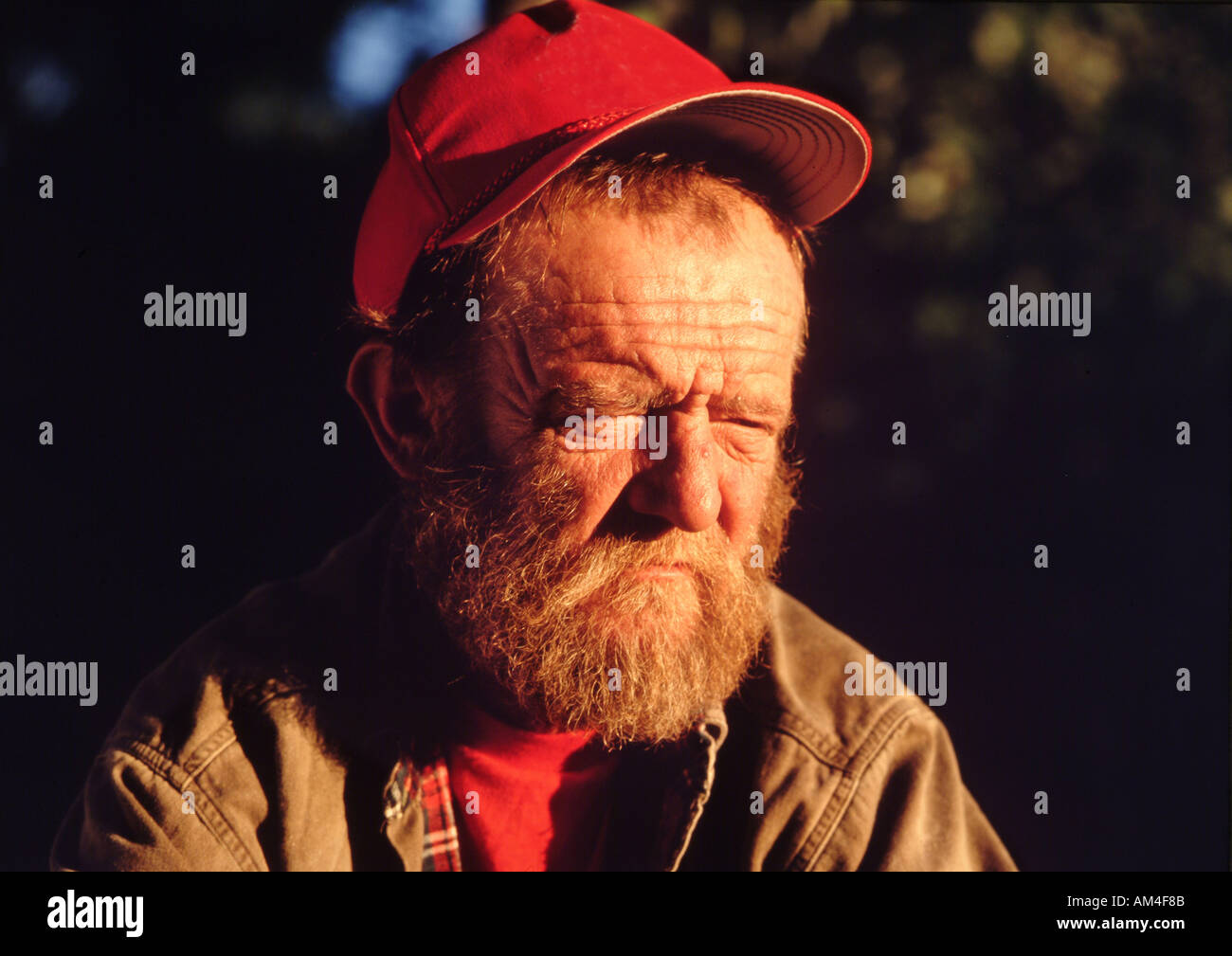 homeless man with a beard and red truckers hat Stock Photo - Alamy