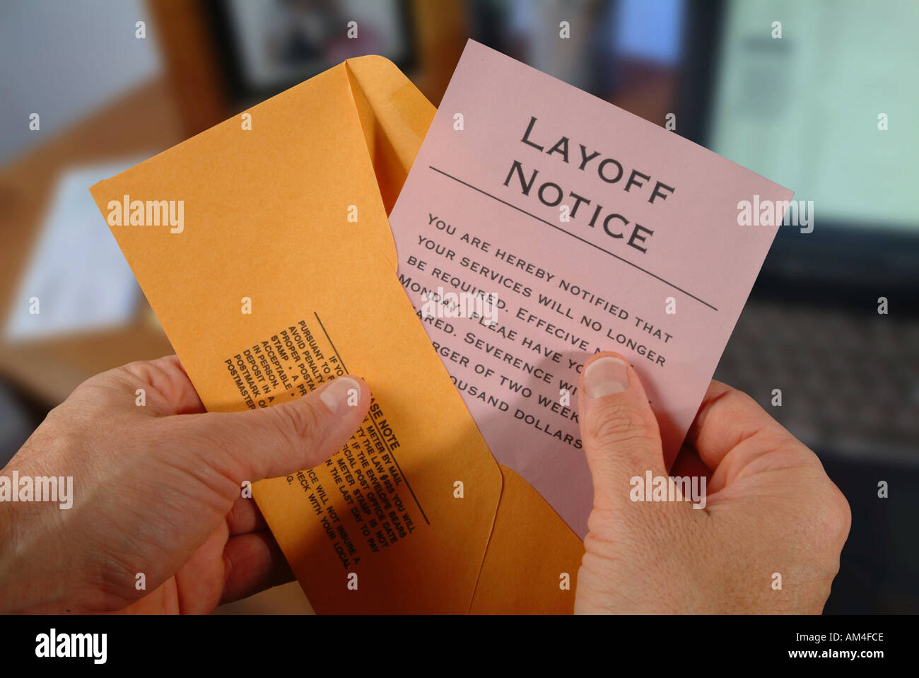 A man removes a lay-off notice from an envelope Stock Photo - Alamy